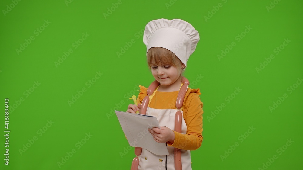 Child girl kid dressed as professional cook chef writing with pen in ...