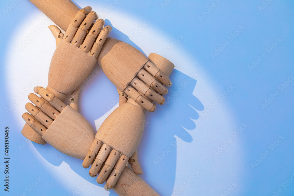 close up of hands holding each other. Two pairs of wooden prosthetic ...