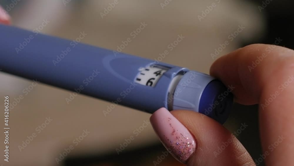 Diabetes patient turn knob on end of insulin pen and dial up correct ...