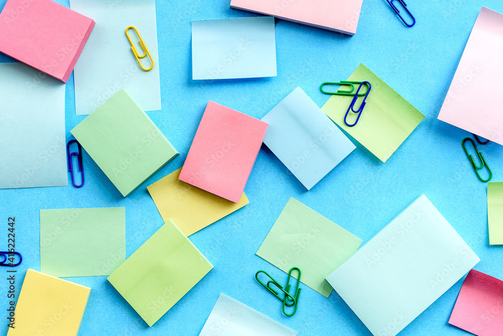 Top view of an office desk with stationery. Stickers on a blue ...