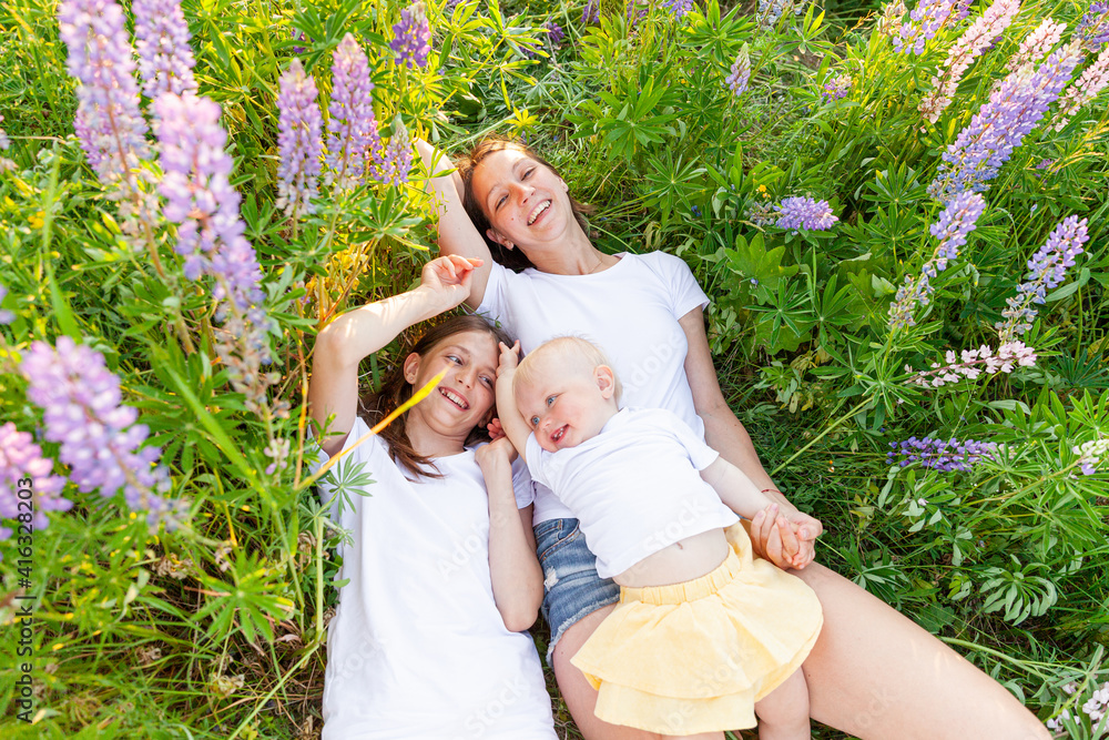 Young mother embracing her kids outdoor. Woman baby child and teenage ...