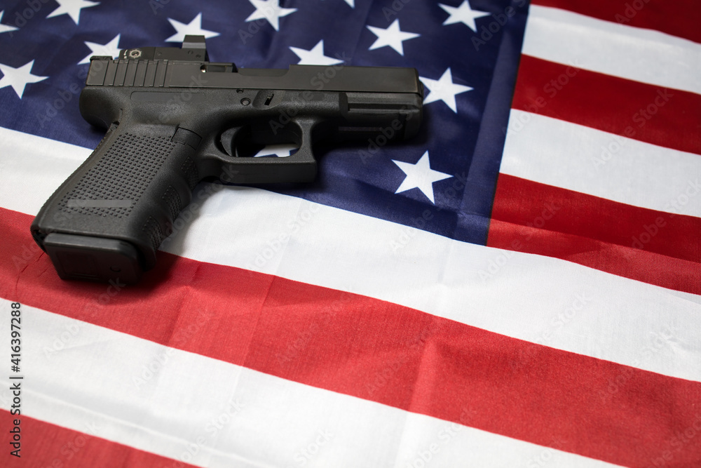 A pistol on the American flag. Gun laws in the USA. Handgun, self ...
