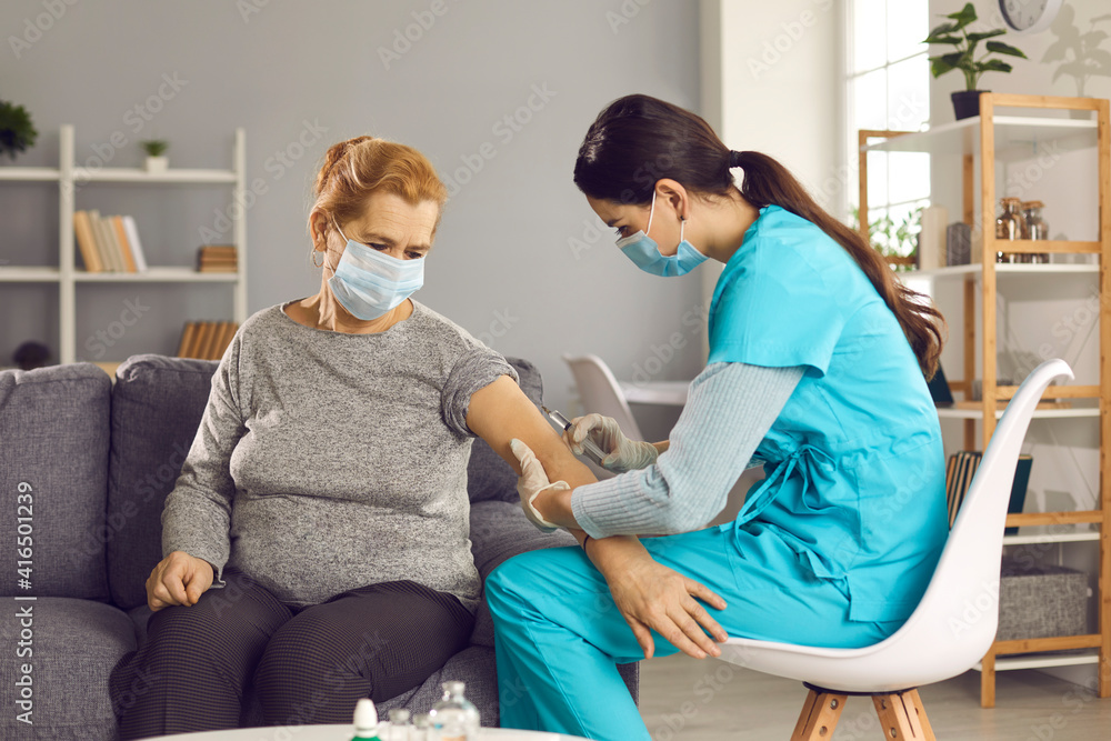 Safe vaccination for old people. Female nurse or doctor in medical face ...