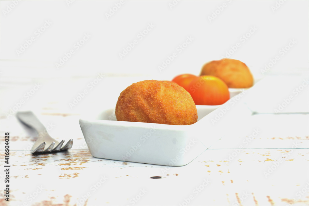 Typical spanish. Croquettes, tomatoes cherrys on a small rectangular ...