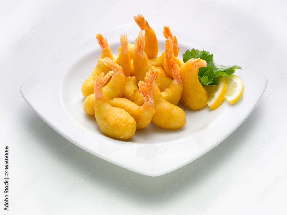 gambas rebozadas y fritas. Con limón sobre fondo blanco. battered and ...