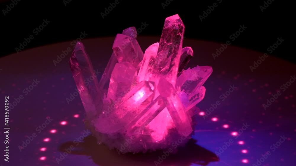 Rhinestone crystal rotates around in colored laser beams. Large ...