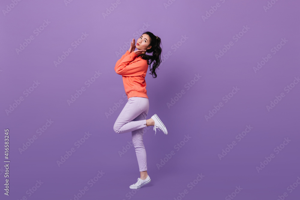 Charming asian girl with ponytail standing on one leg. Full length view ...