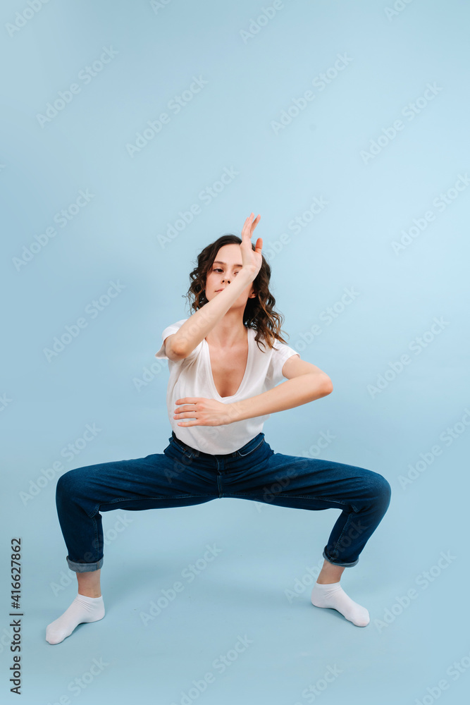 Pretty contemporary dancer poses in front of blue studio background ...