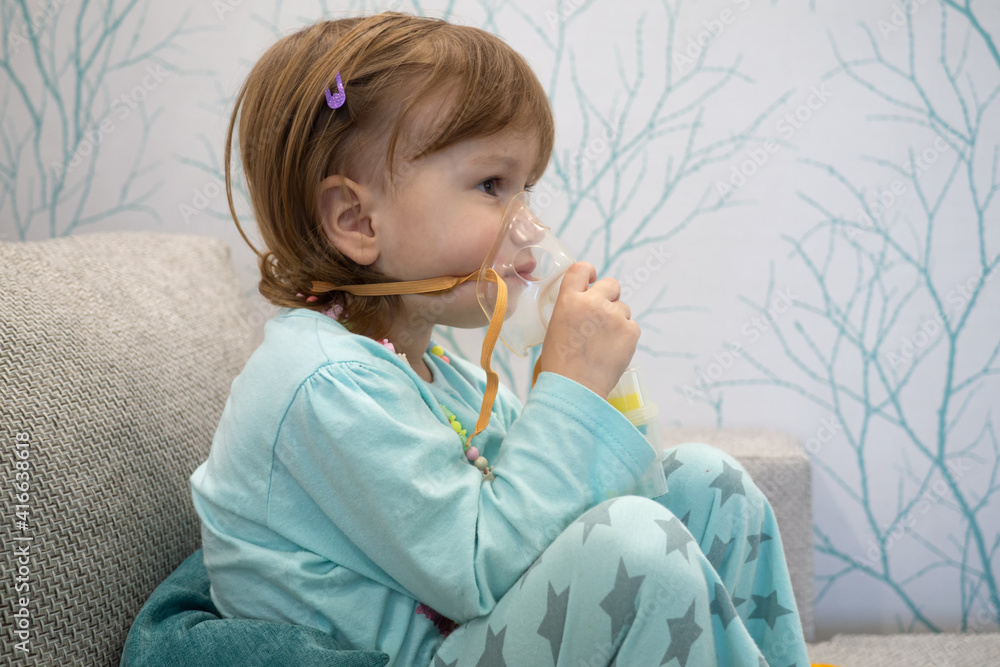 Kid girl makes inhalation with a nebulizer. sick child holding ...