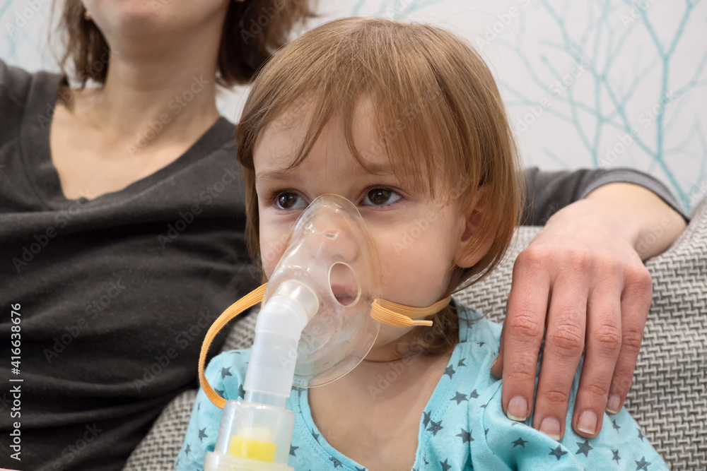 Kid girl makes inhalation with a nebulizer. sick child with mother ...