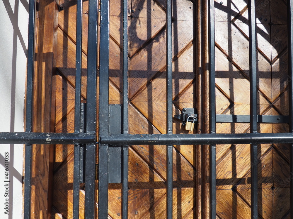 Foto de Wooden doors behind metal bars. The entrance to the church is ...