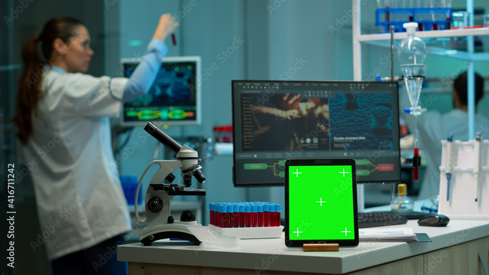Team of scientists working in background of modern laboratory using ...