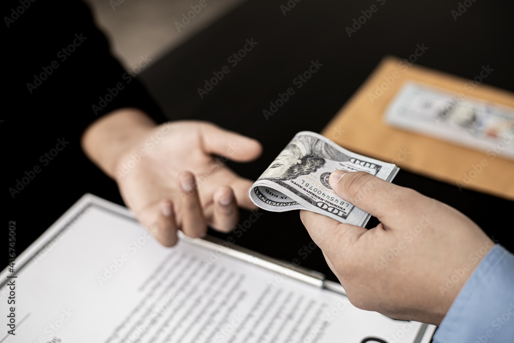 Business men fold the dollar bills and give them to their business ...
