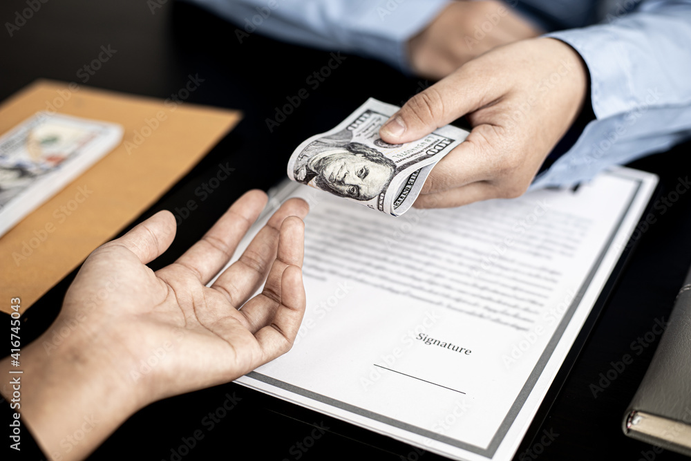 Business men fold the dollar bills and give them to their business ...