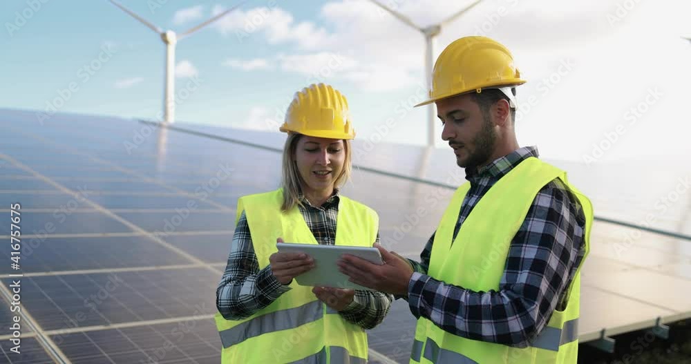 Young people working with digital tablet at solar panels station and ...