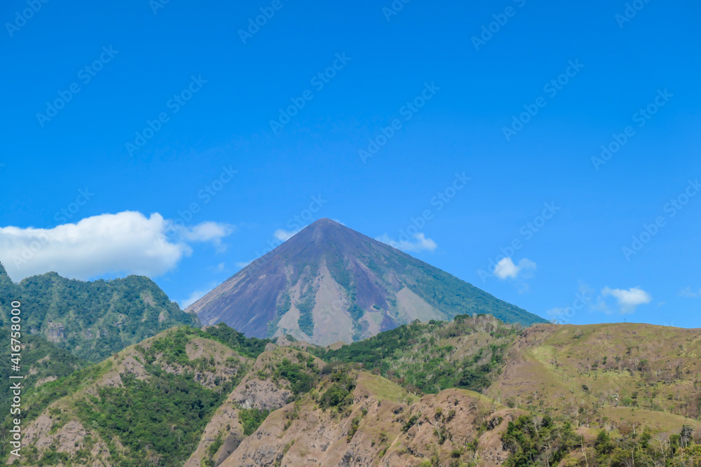 A distant view on Volcano Inierie, Bajawa, Indonesia. The pyramid like ...
