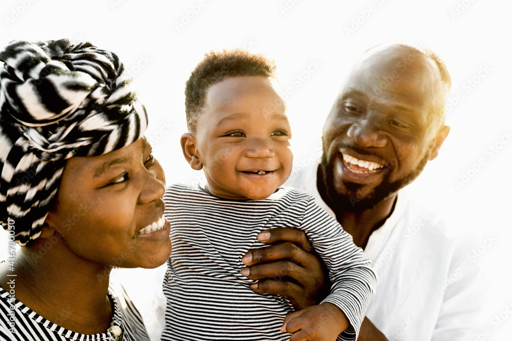 Happy African family having fun on the beach during summer holidays ...