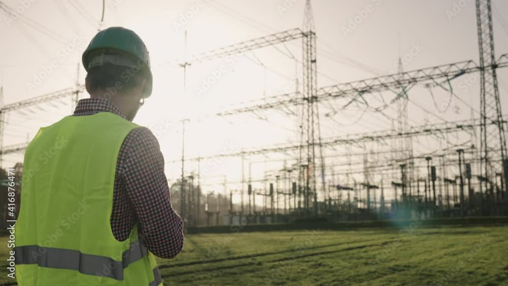 Electrical engineer wearing a helmet and safety vest working with ...
