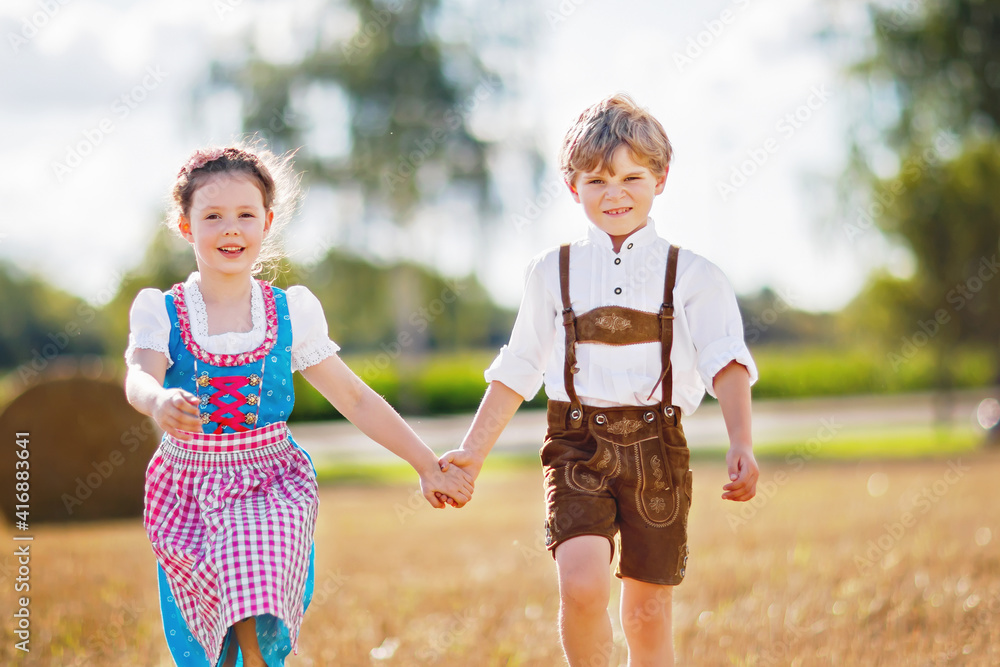 Two kids in traditional Bavarian costumes in wheat field. German ...