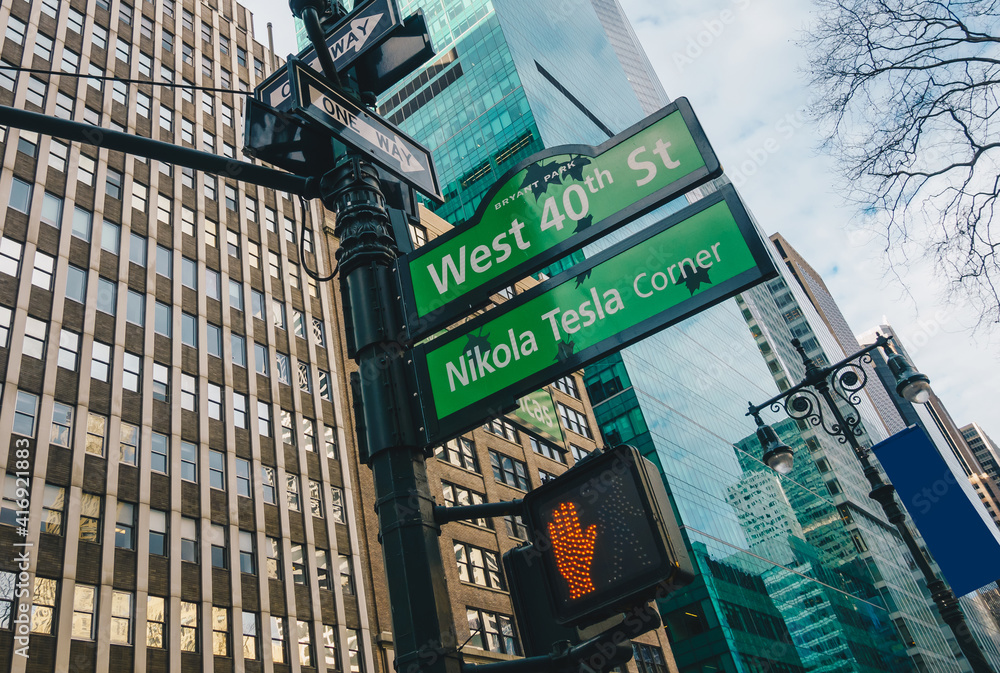 Street sign of Nikola Tesla corner and West 40th St with skylines in ...
