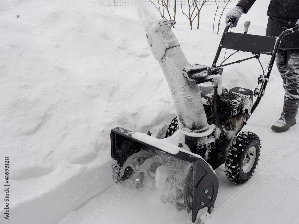 Clearing snow with a snowblower Stock Photo | Adobe Stock
