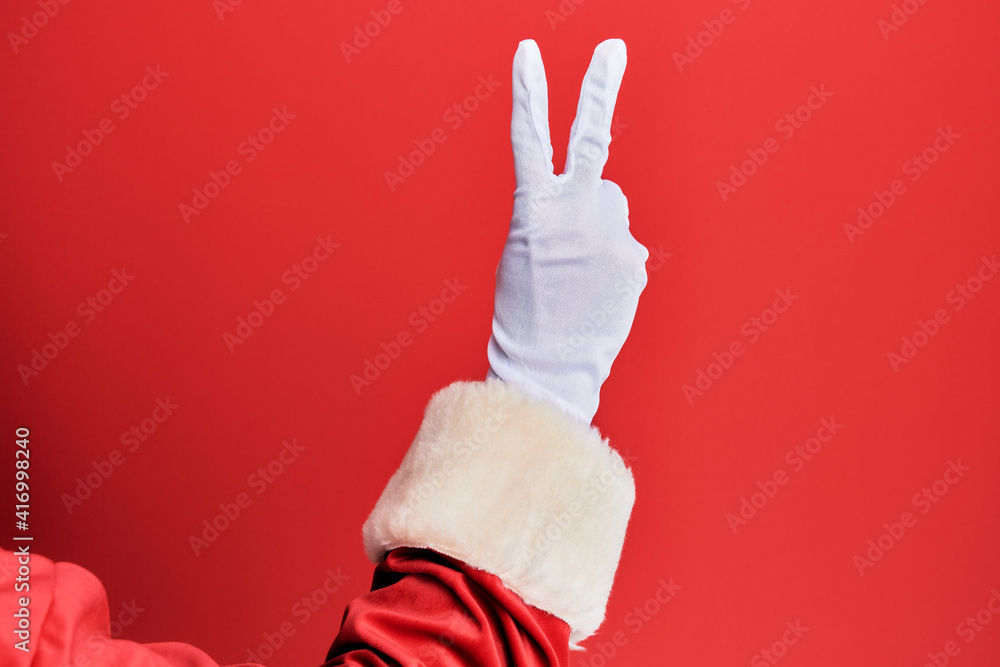 Hand of a man wearing santa claus costume and gloves over red ...