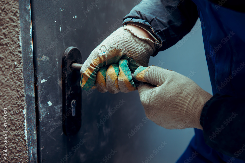 Aggressive robber thief breaks open the front metal door with ...