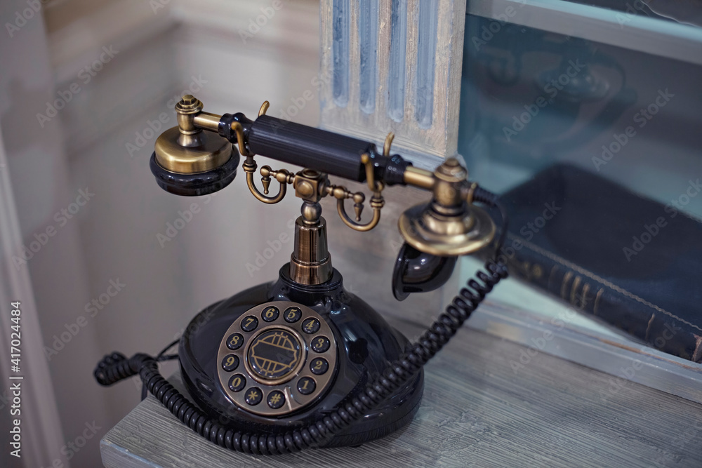 An old Fashioned rotary telephone sitting on a desk. This is a ...