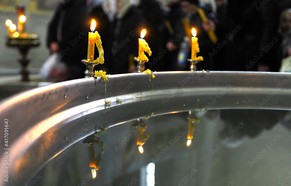 Reflection of three candles in the water standing on the edge of the ...