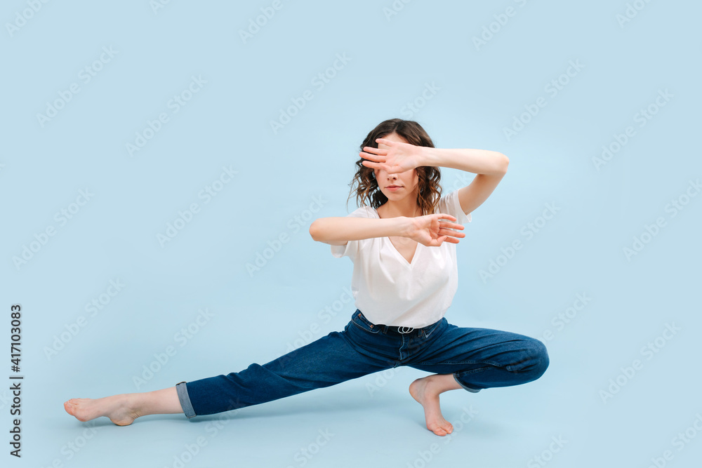 Precise contemporary dancer poses in front of blue studio background ...