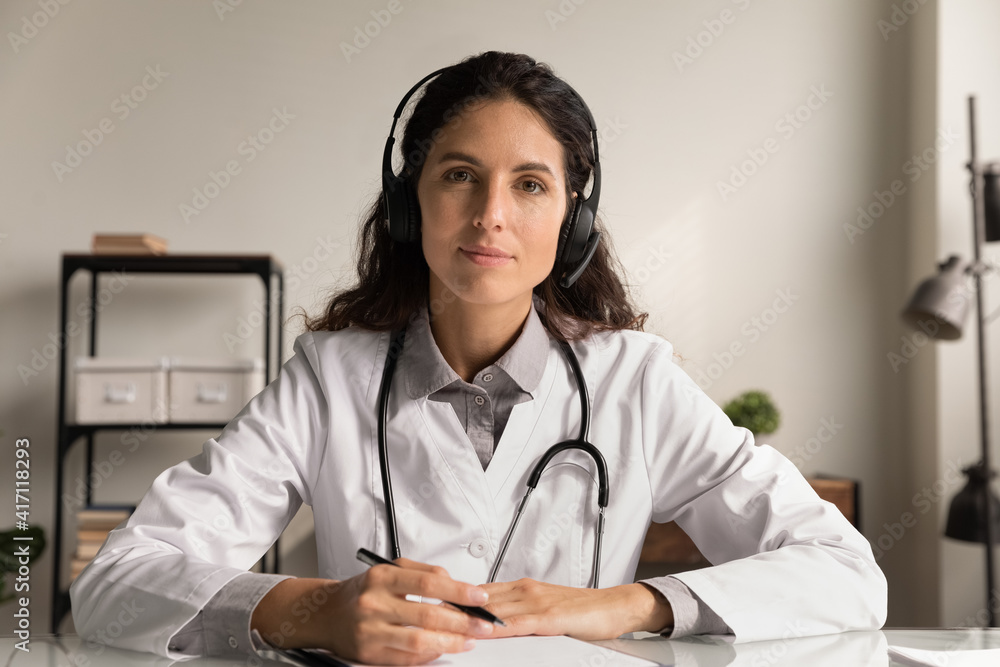 Head shot portrait confident female doctor wearing headphones and ...