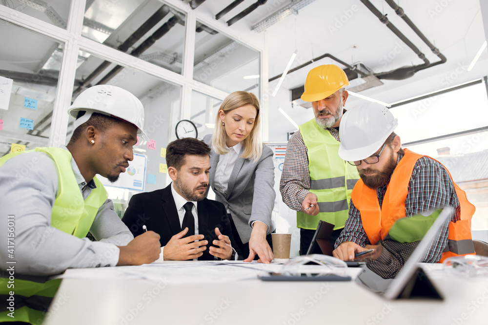 Concentrated professional multiracial team of male and female engineers ...