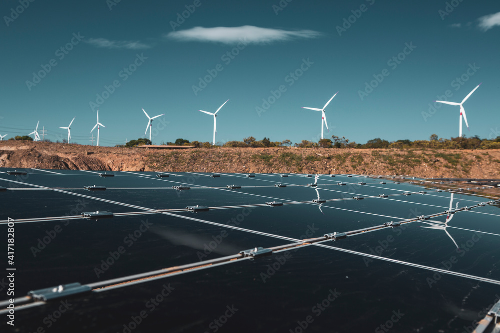 Wind farm and solar panels under a beautiful blue sky with a few clouds ...