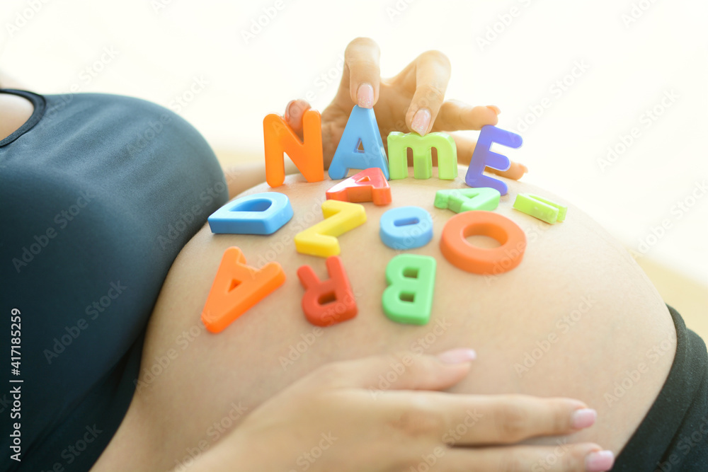 choose name for your baby concept with pregnant mother holding colorful ...