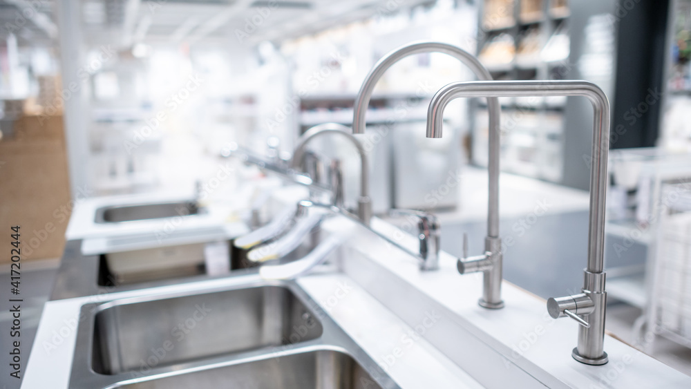 Male hand choosing stainless steel water tap in furniture store. Home ...