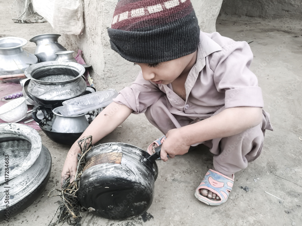 a poor and cute boy washing dishes cause of poverty Stock Photo | Adobe ...