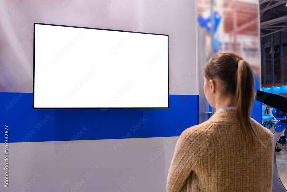 Woman looking at blank digital interactive white display wall at ...