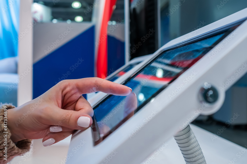 Woman hand using touchscreen display of interactive floor standing ...
