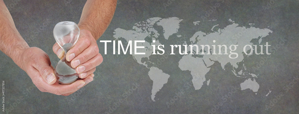 Time Is Running out for our World Concept - male hands holding an hour ...
