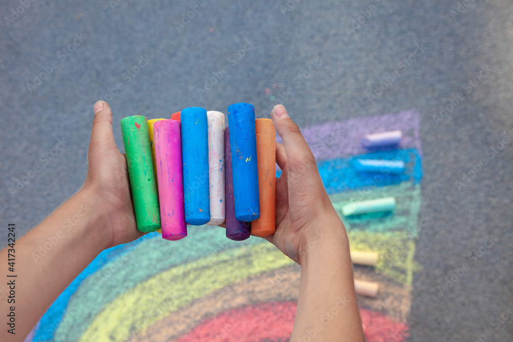 Chalks. Large multi-colored crayons in children's hands. The child ...