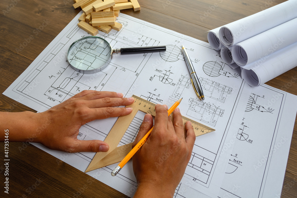 Mechanical engineer at work. Technical drawings. Paper with technical ...
