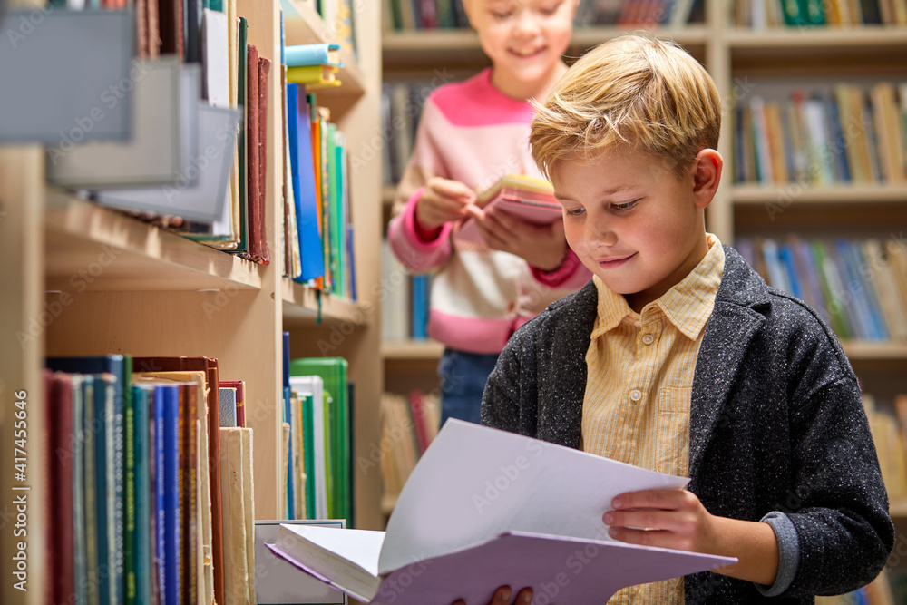 preschool boy reading book in library with patience, caucasian kid boy ...