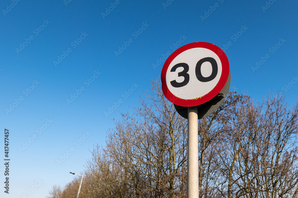 Foto de A slightly dented speed limit sign in the UK with lichen ...