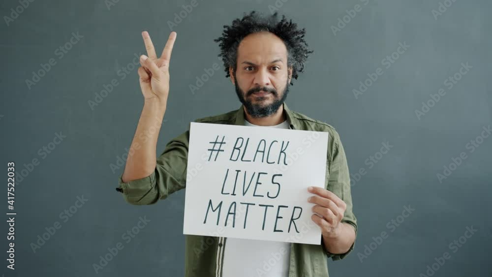 Portrait of mixed race activist holding Black Lives Matter poster ...
