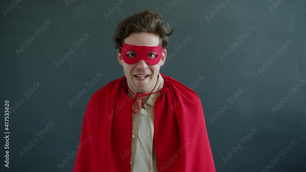 Aggressive guy wearing superman costume looking at camera with ...