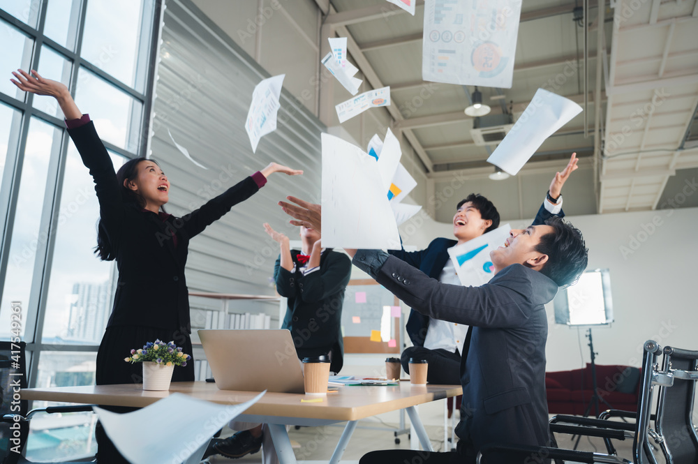 Team of LGBT business people throws paper in joy of meeting their goals ...
