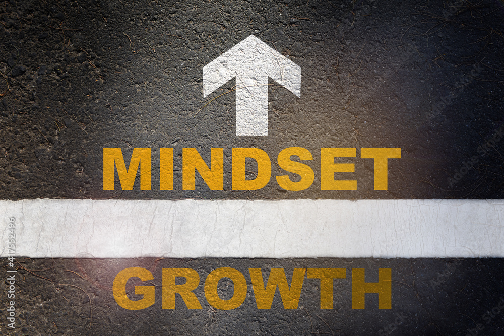 Growth mindset and white arrow written on asphalt road surface with ...