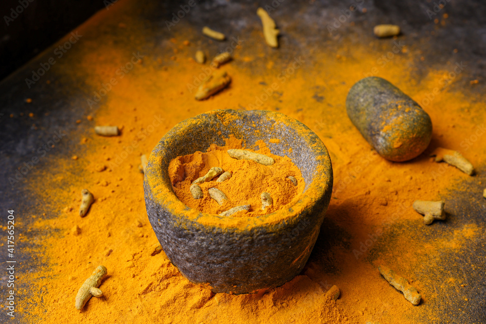 Woman hand powdering Indian spices turmeric powder stone mortar Kerala ...