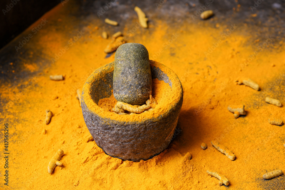 Woman hand powdering Indian spices turmeric powder stone mortar Kerala ...