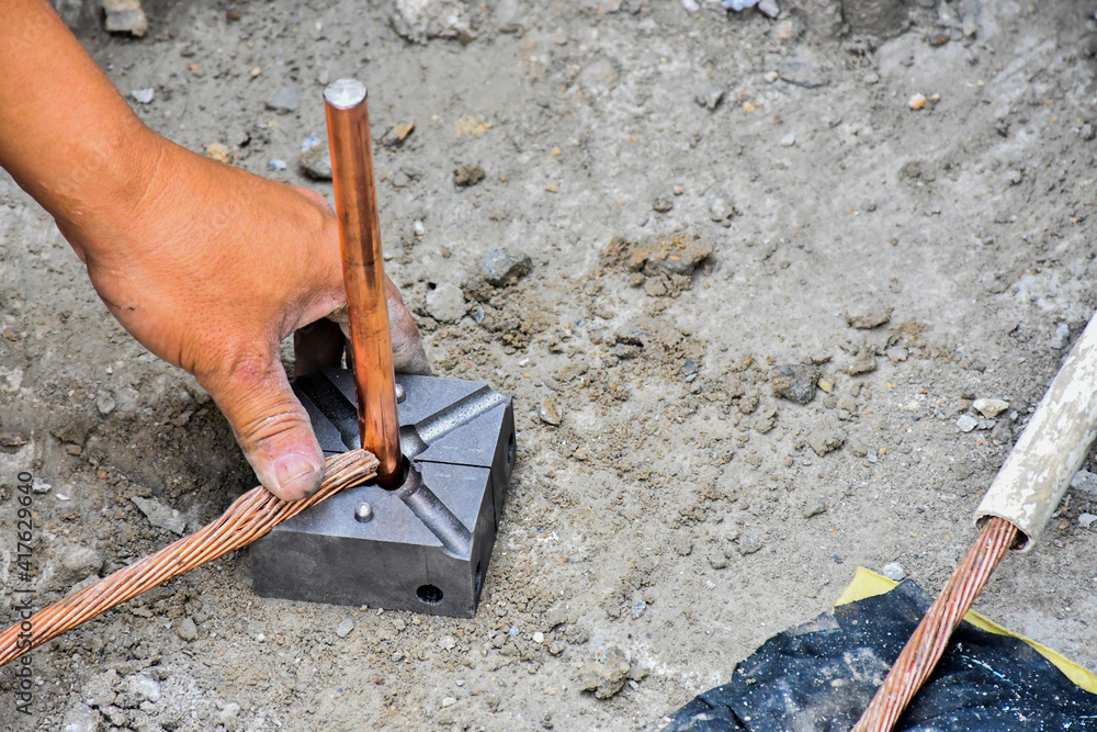 Workers working on protective earth system, used in construction of ...